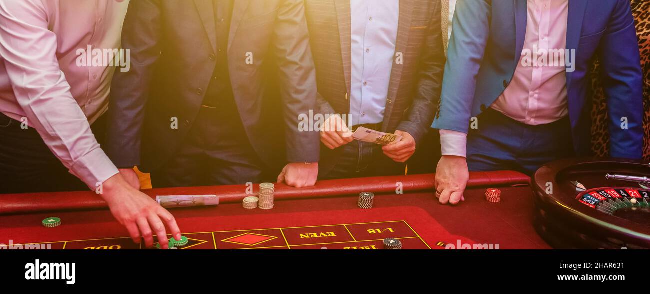 Group of people behind roulette gambling table in luxury casino ...