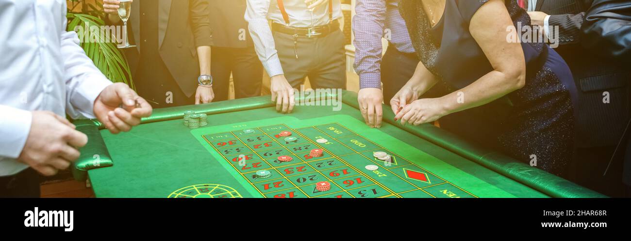 Group of people behind roulette gambling table in luxury casino ...