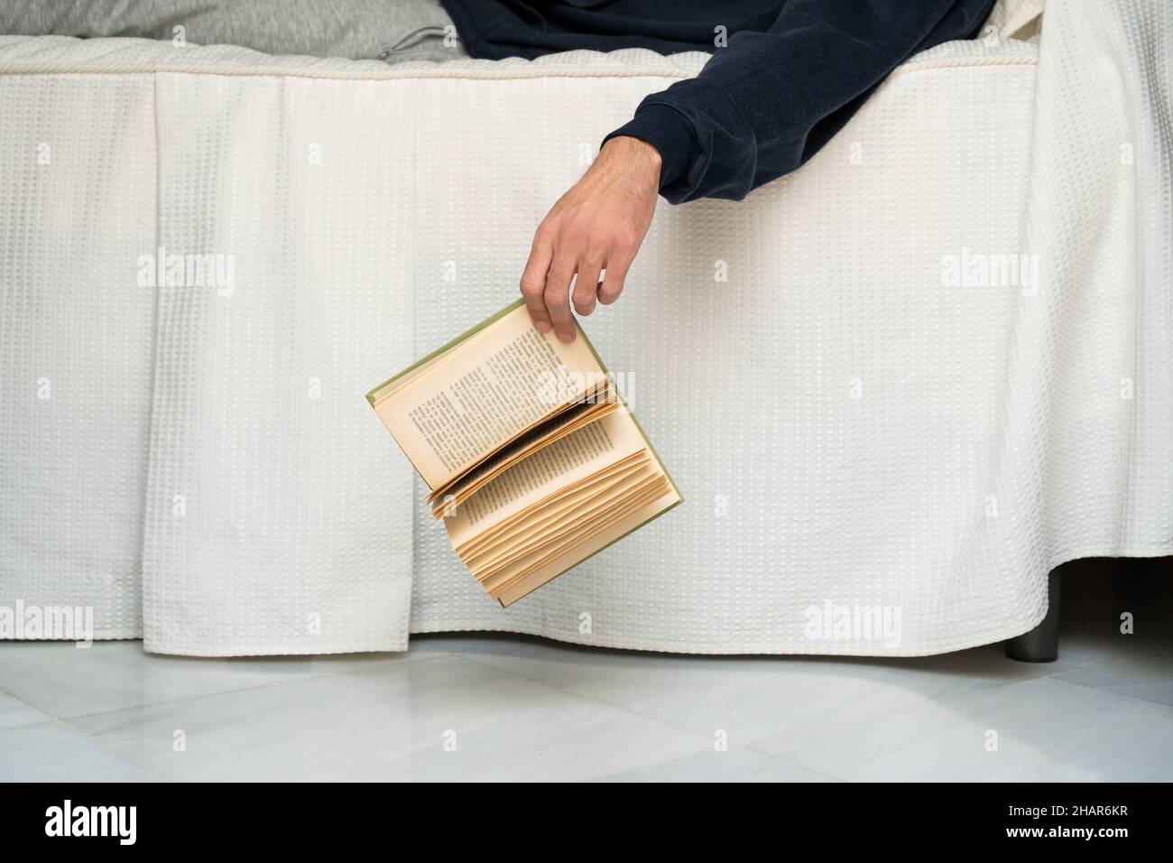 Person falls asleep while reading a book, concept of boredom at home ...