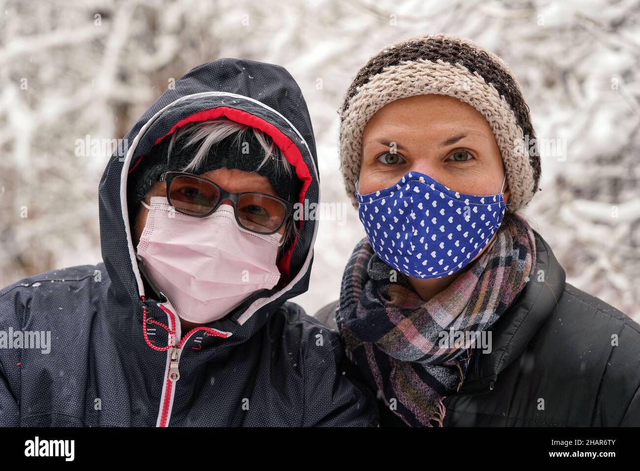 Elderly senior woman and her younger daughter in winter clothes, both ...