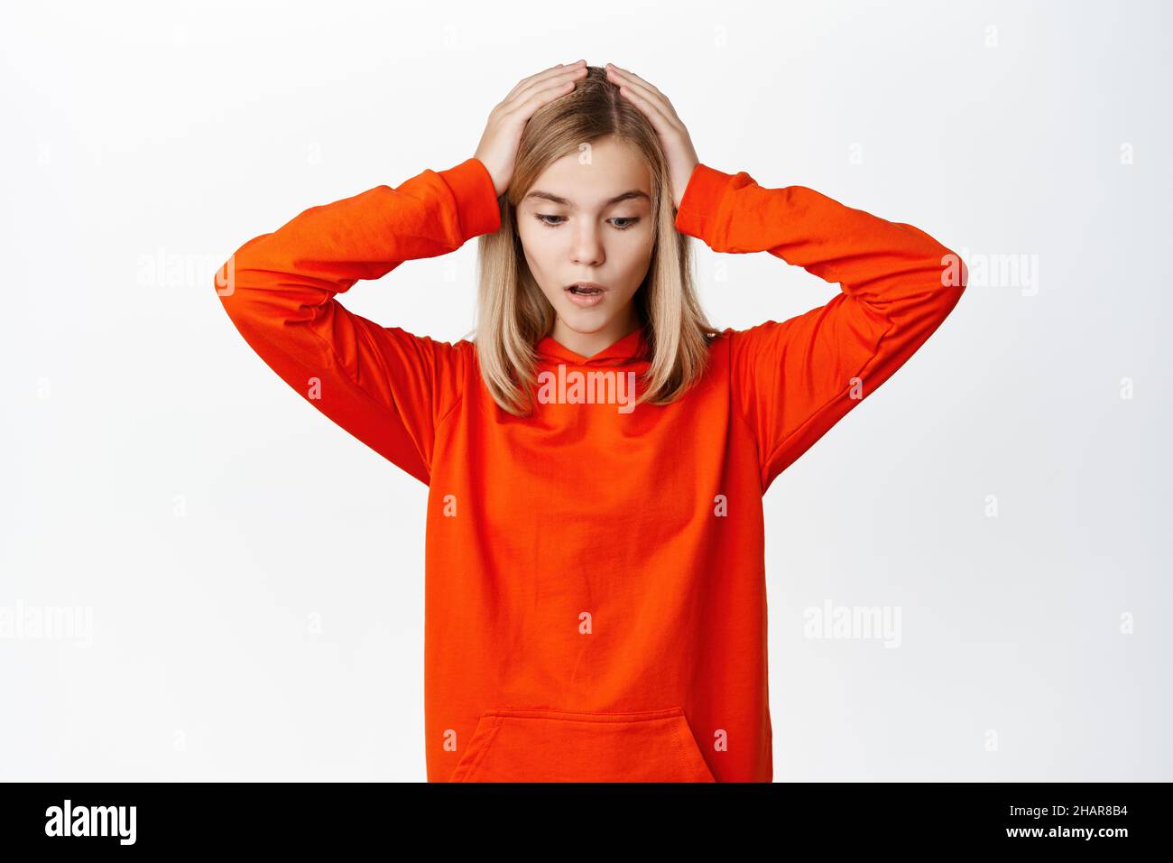 Shocked and worried little girl, child in panic looking down, gasping ...