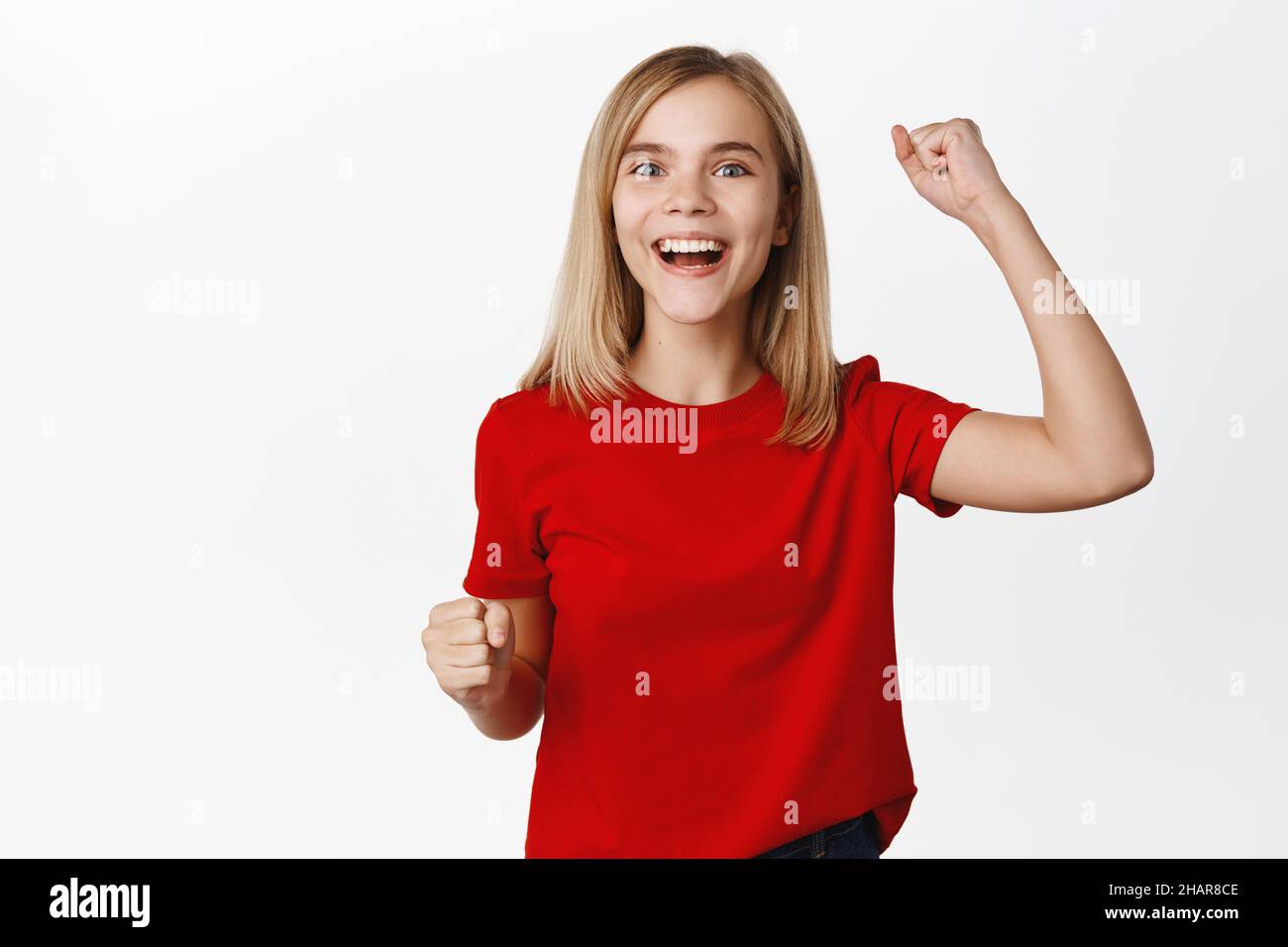 Cheerful beautiful little girl, chanting and celebrating, making fist ...