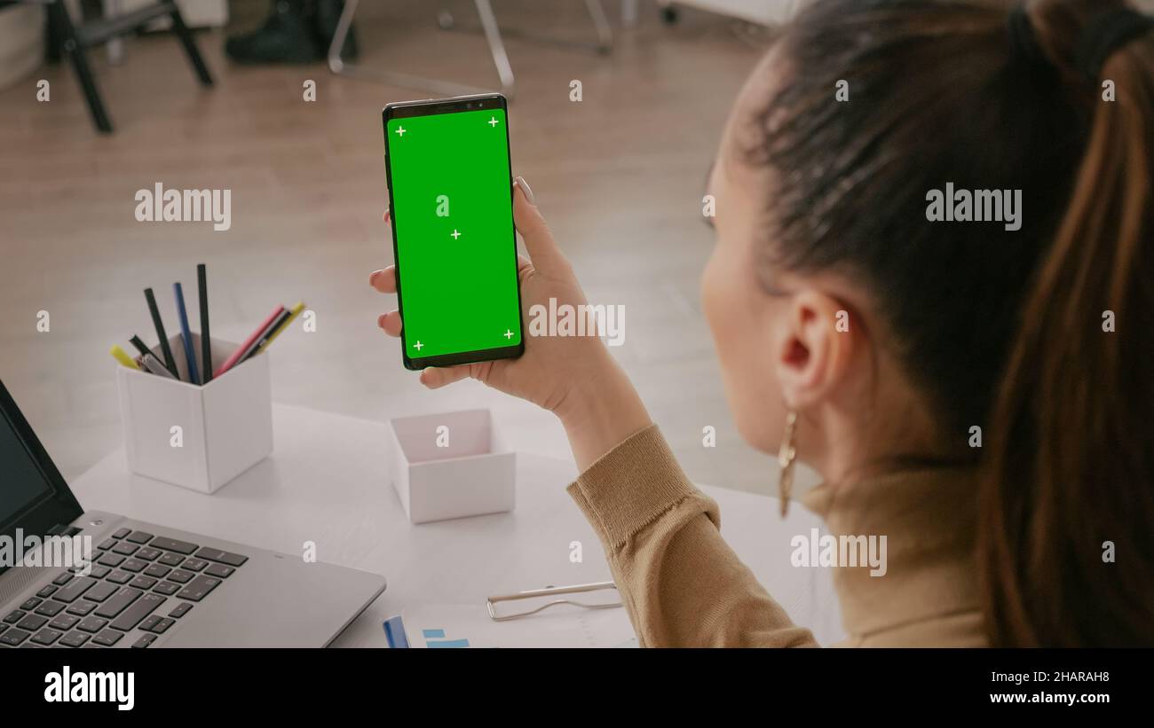 Close up of woman vertically holding green screen on smartphone. Mobile ...