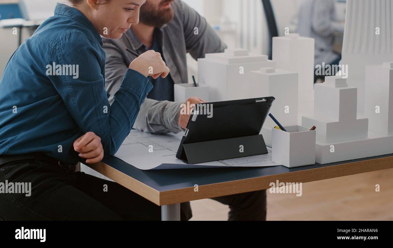 Close Up Of Colleagues Working With Tablet And Building Model To Design Construction Layout Man