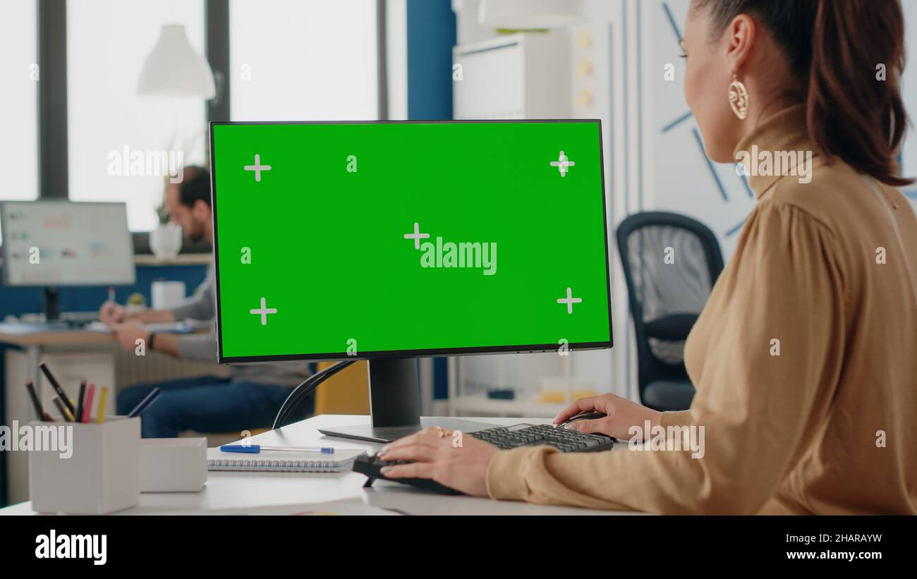 Close up of woman using computer with isolated green screen on display ...