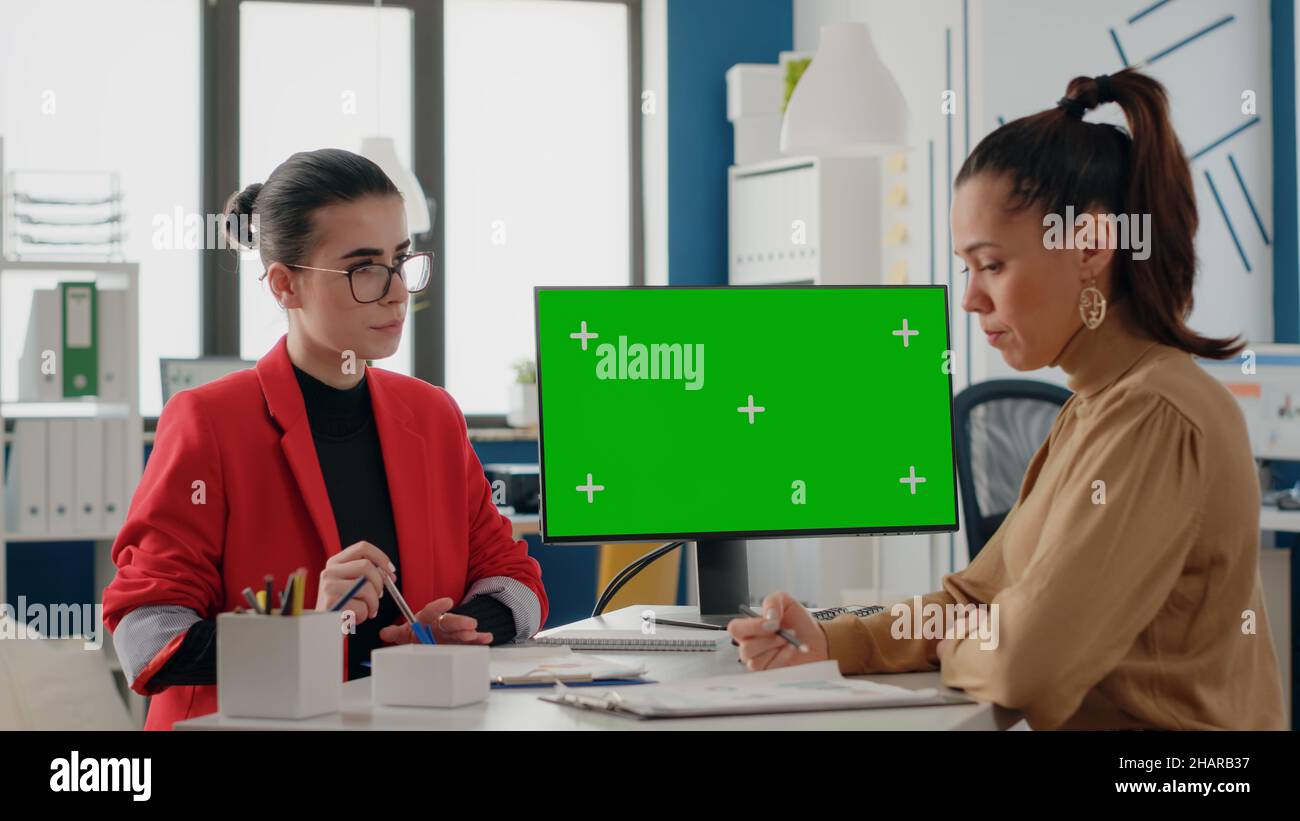 Women doing teamwork with isolated green screen on computer in business ...