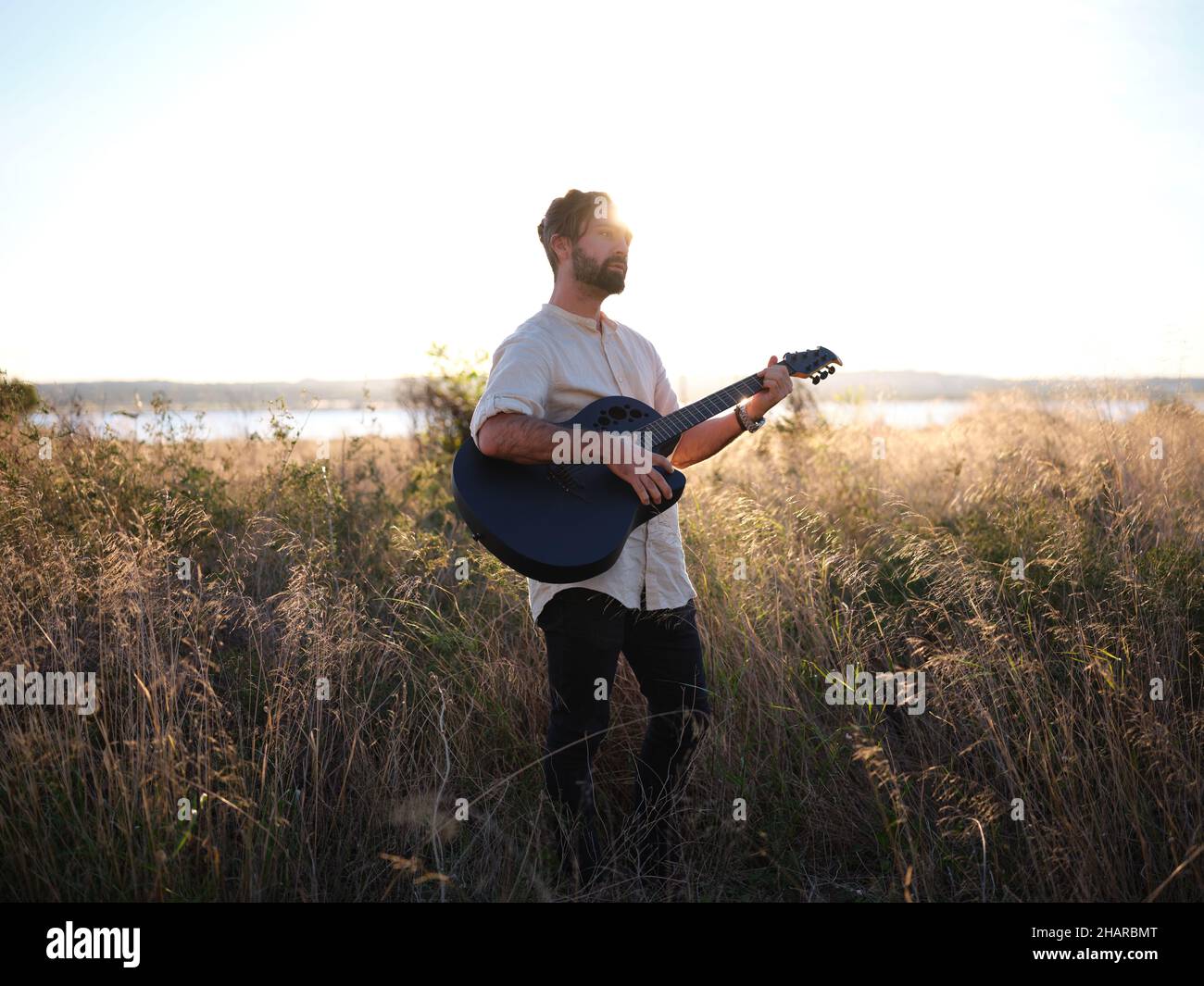guitarist posing with his guitar in the countryside during sunset Stock ...