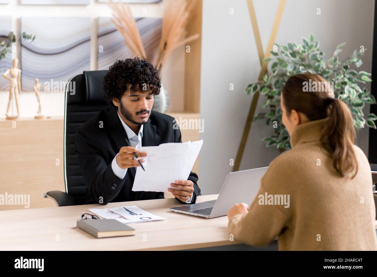 Serious successful Indian HR manager, entrepreneur, interviewing girl ...