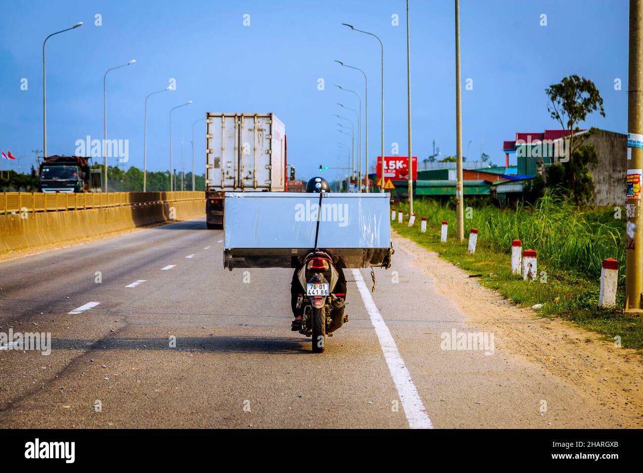 Transporting a refrigerator by motorbike in VN. as seen from behind ...