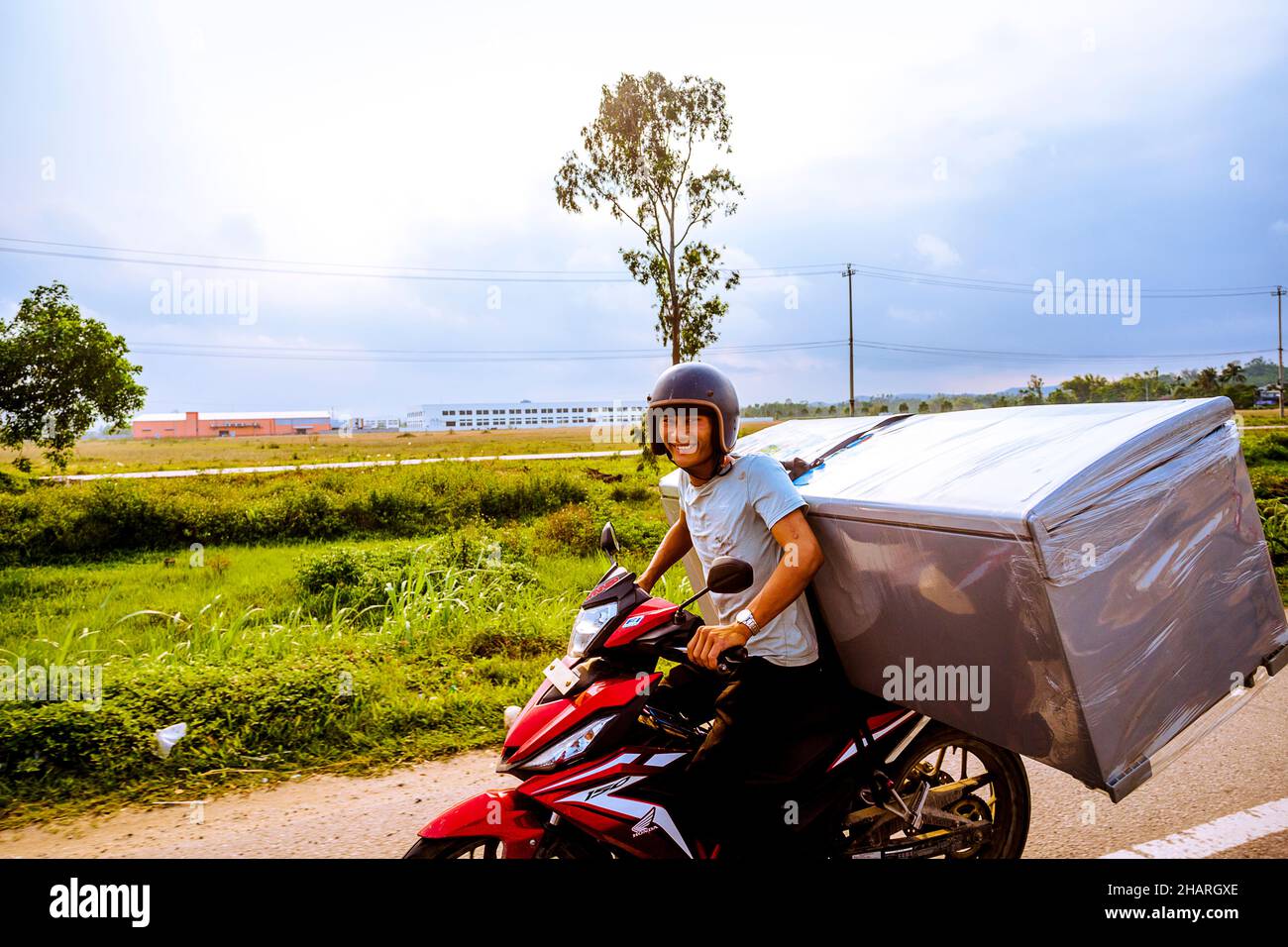 Transporting a refrigerator by motorbike in VN from the front side ...