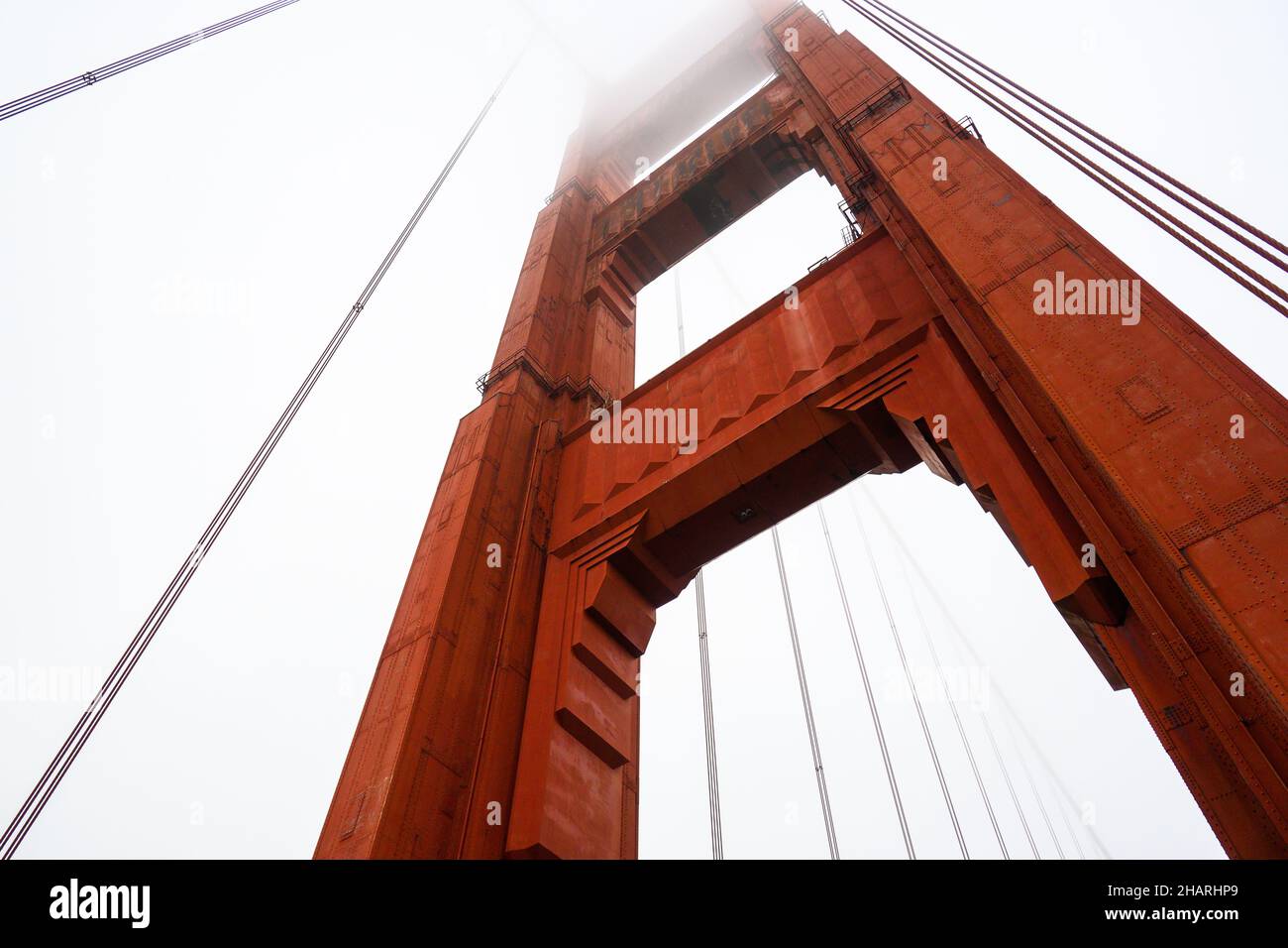 Low angle shot of the Golden Gate bridge over the river on a cold foggy ...