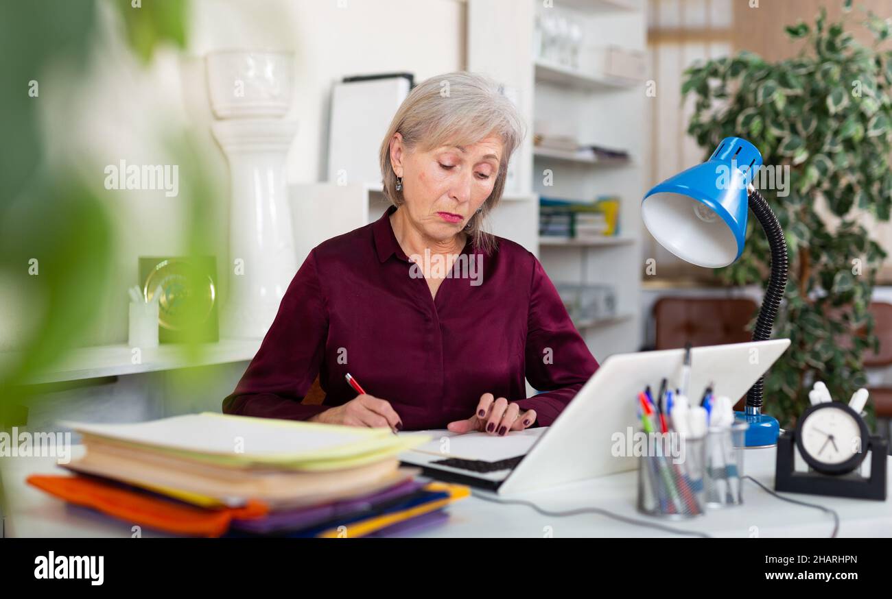 Stressed mature woman working in office Stock Photo - Alamy