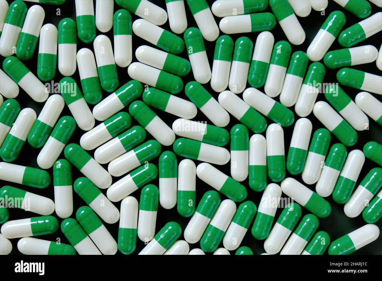 Green homeopathic capsules on a green background. Alternative medicine ...