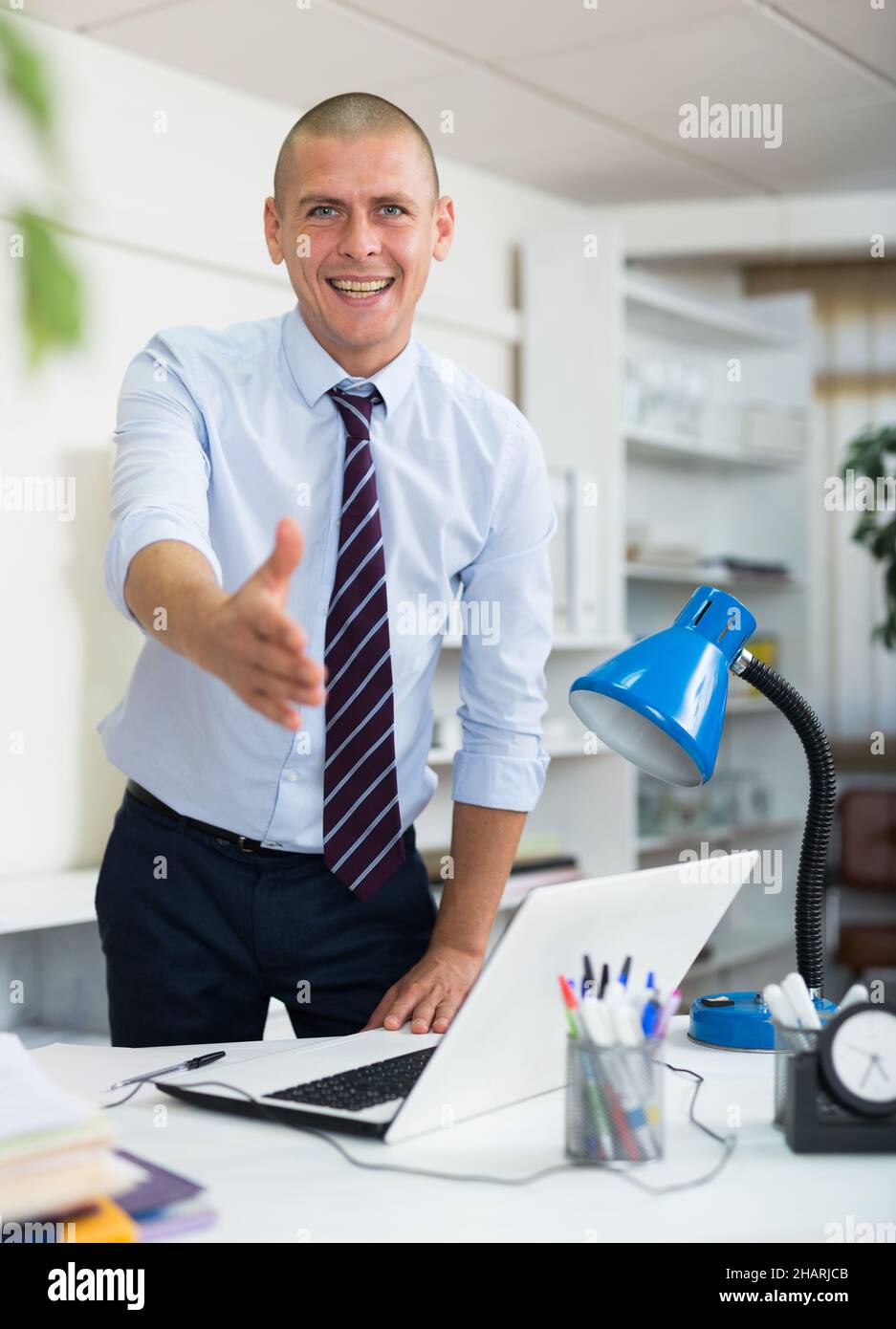 Business man with hand extended to handshake in modern office Stock ...