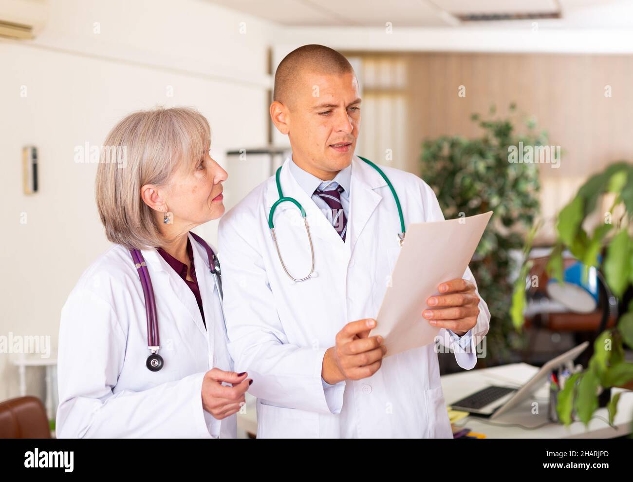 Two doctors discussing medical documentation Stock Photo - Alamy