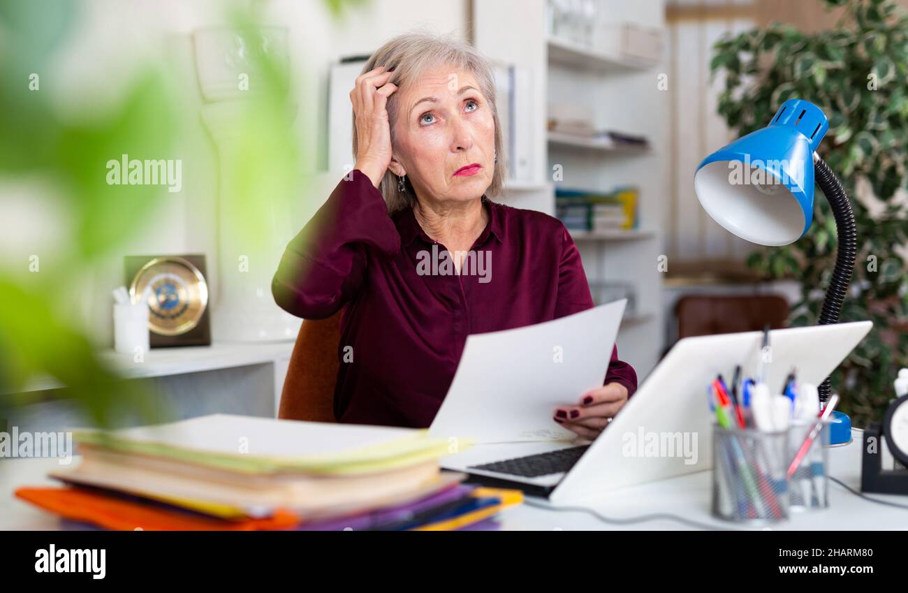 Stressed mature woman working in office Stock Photo - Alamy