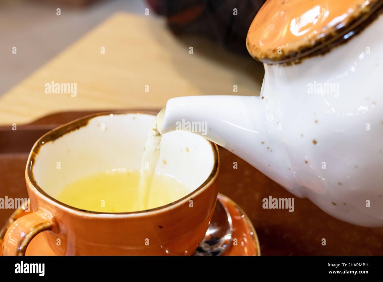 Tea is pouring from the teapot into the cup Stock Photo - Alamy