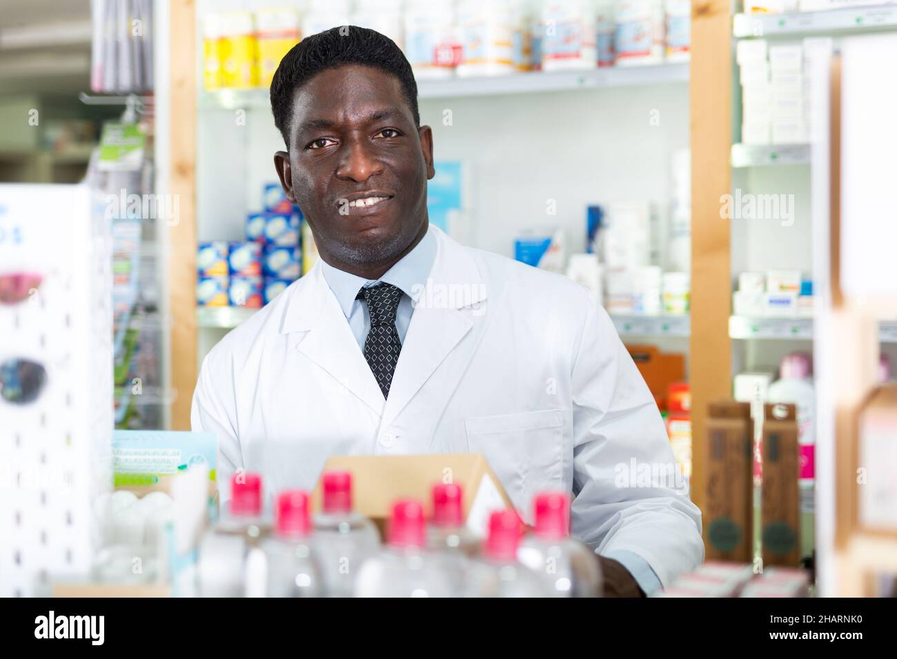 Portrait of an african american male pharmacist standing in the sales ...