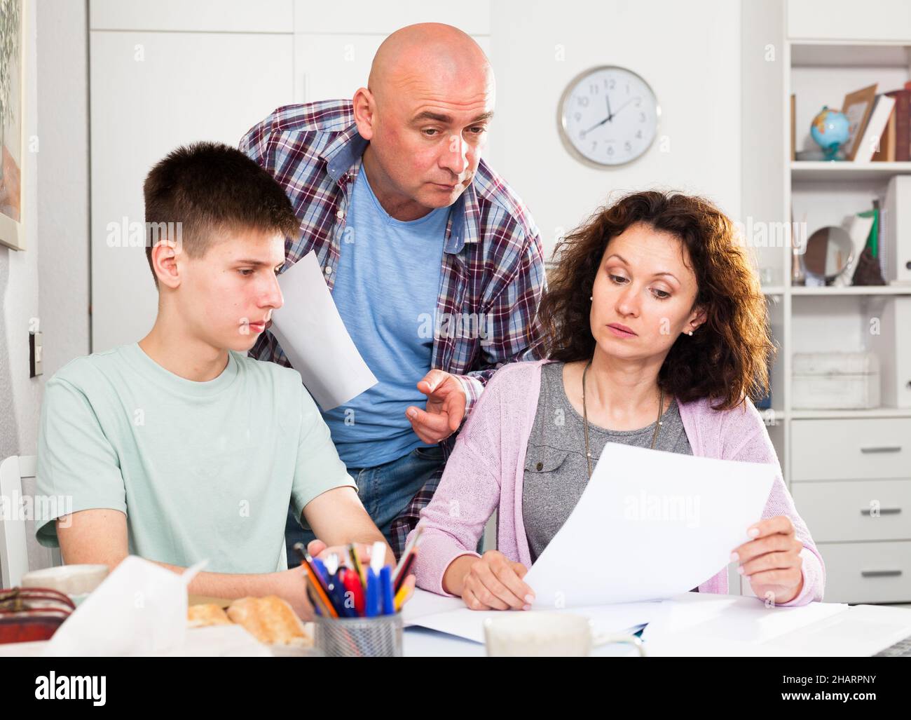 Parents with teenager son reading documents Stock Photo - Alamy