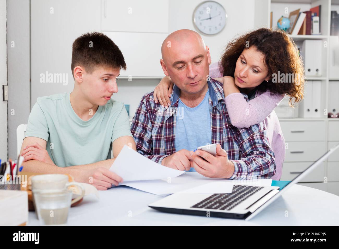 Parents with teenager son reading documents Stock Photo - Alamy