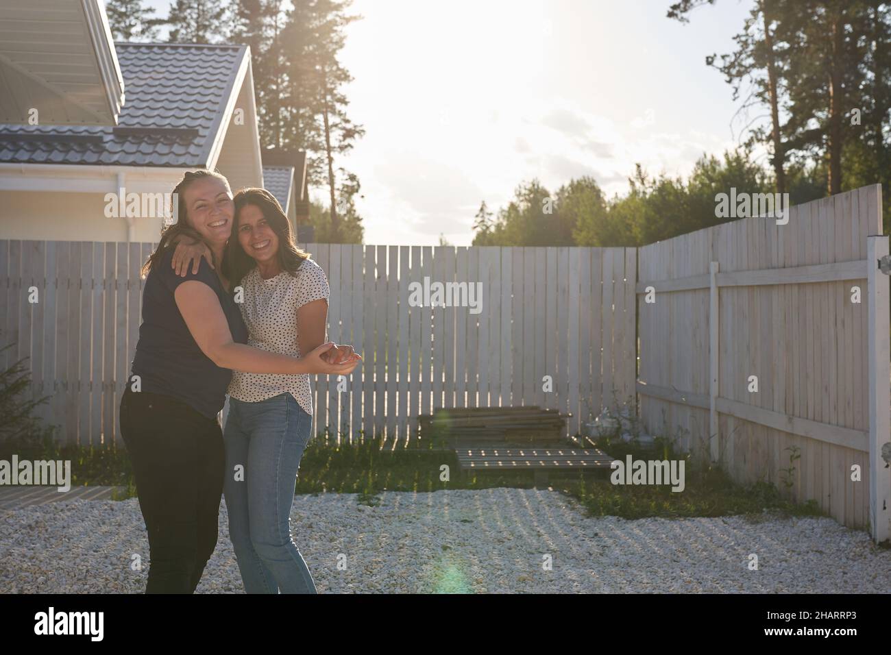 Friends have fun on a day off. Two friends hug and laugh together ...