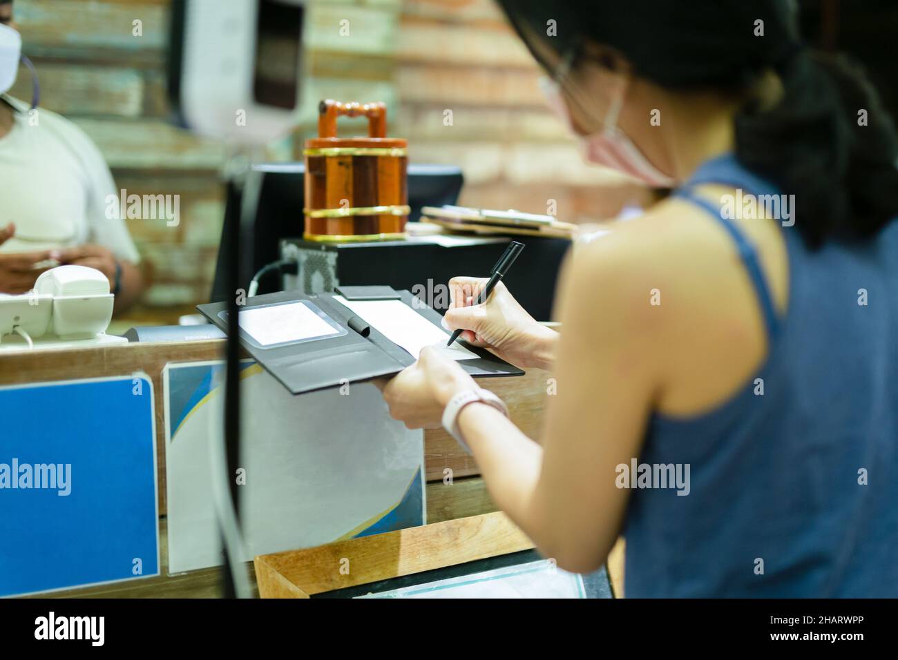Woman in protective mask signing slips payment credit card in ...