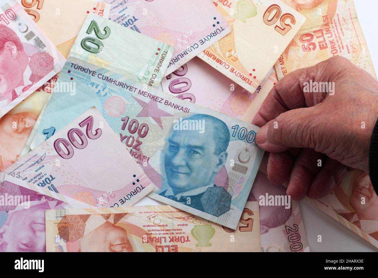Turkish banknotes on white background and hand of adult person holding ...
