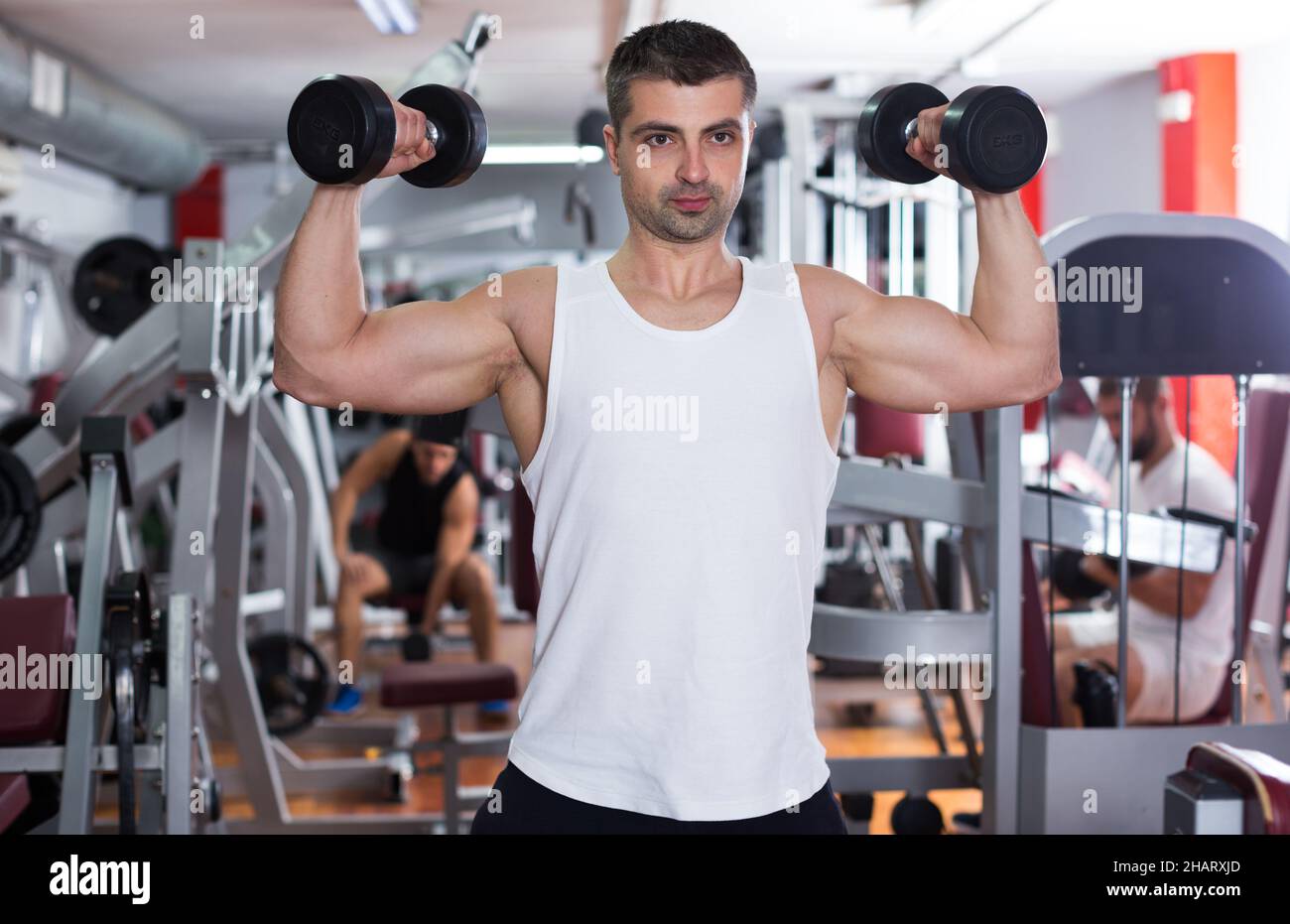 Guy during workout in gym with dumbbells Stock Photo - Alamy