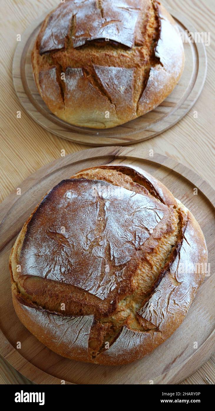 Two,rustic, whole-wheat round homemade whole bread on wooden table ...