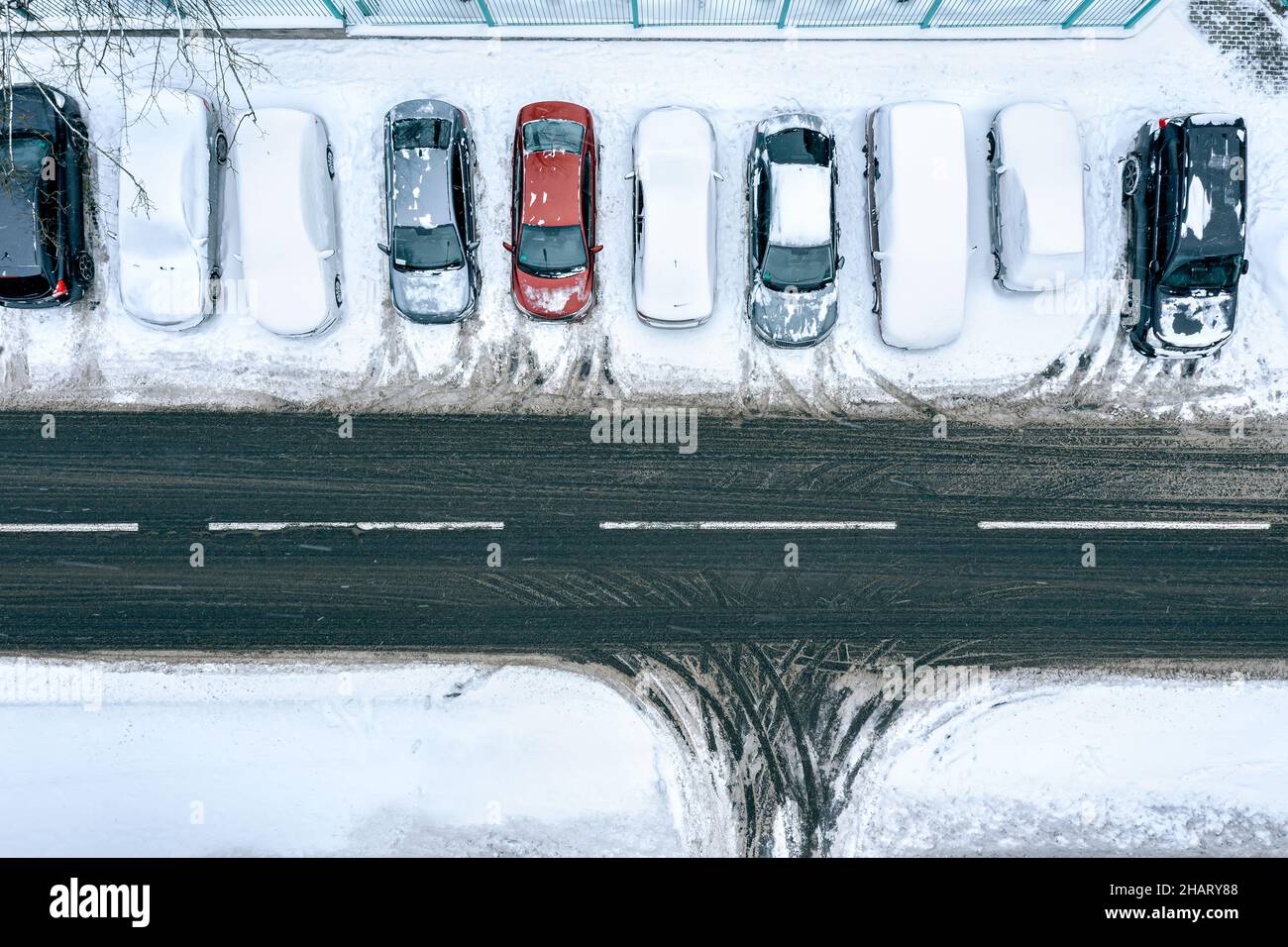 aerial top view of parked cars on city street after snowfall. aerial ...