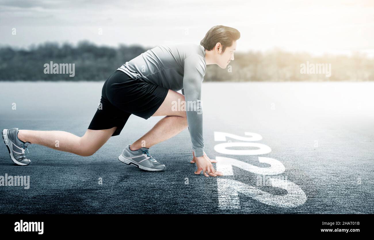 Asian runner man ready to run on the 2022 line. Happy New Year 2022 ...