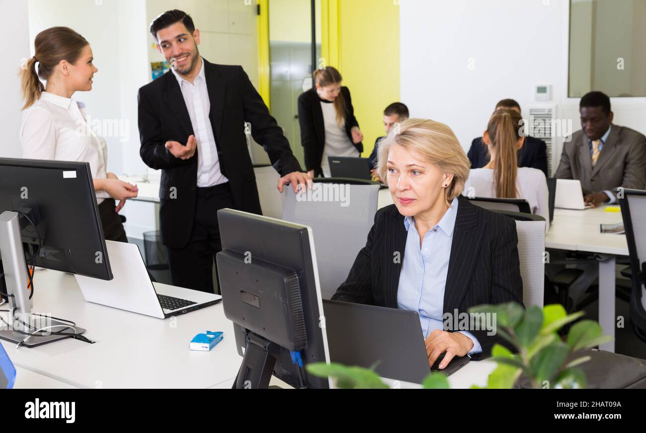 Coworkers engaged in open plan office Stock Photo - Alamy
