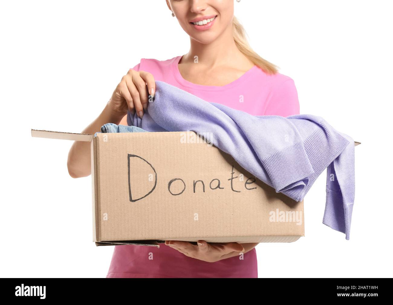 Beautiful woman holding box with donation clothes on white background ...
