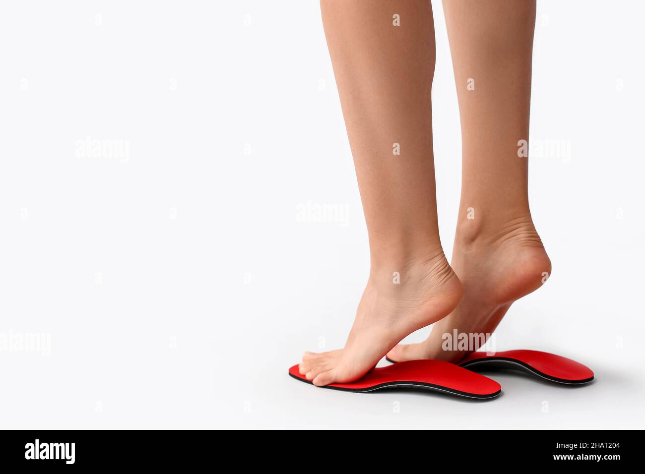 Female feet and red orthopedic insoles on light background Stock Photo ...