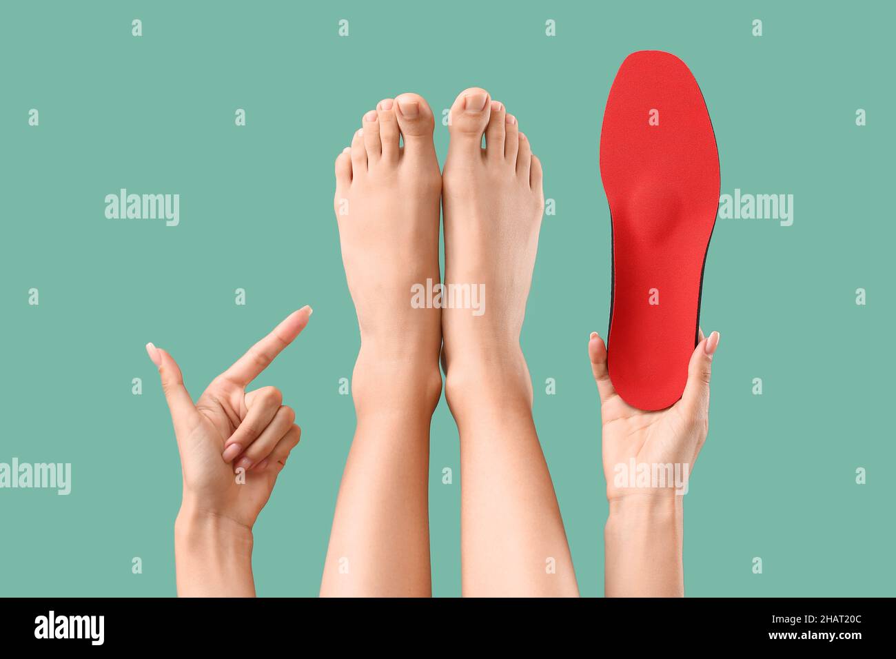 Woman with red orthopedic insole pointing at her feet on green ...