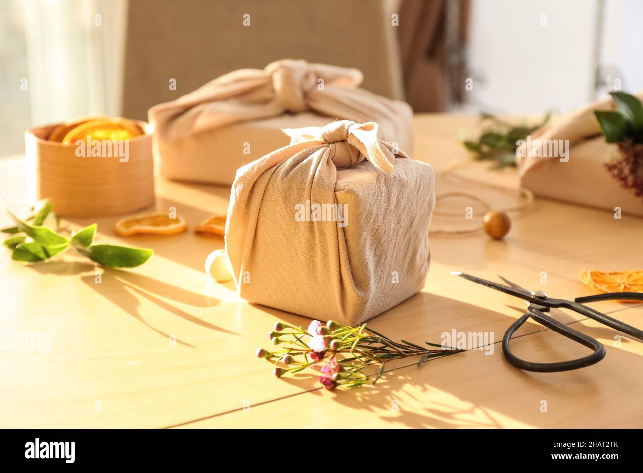 Gift box wrapped in fabric and decor on table in room Stock Photo - Alamy
