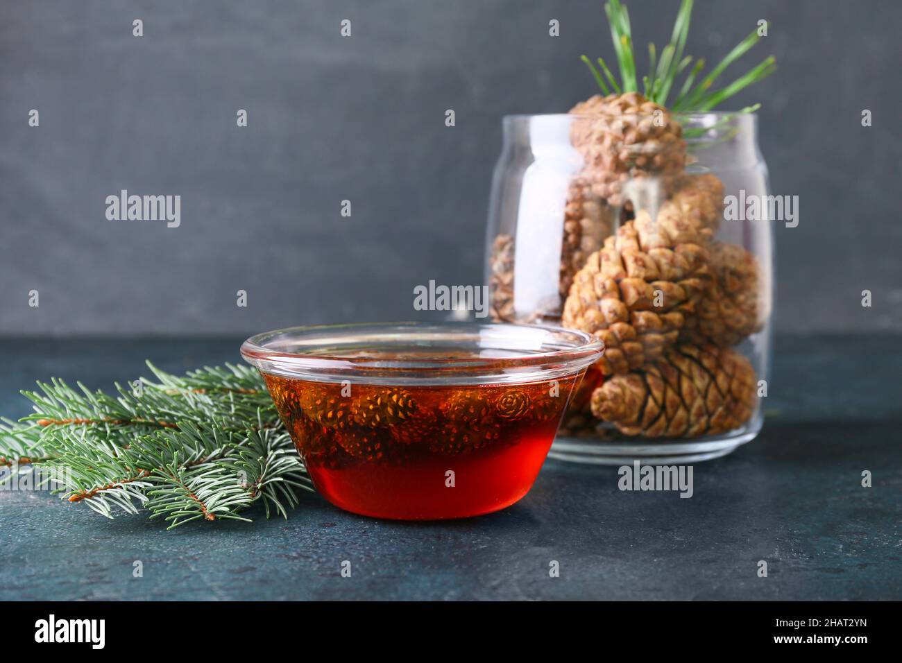 Bowl of tasty pine cone jam and fir tree branch on dark background ...