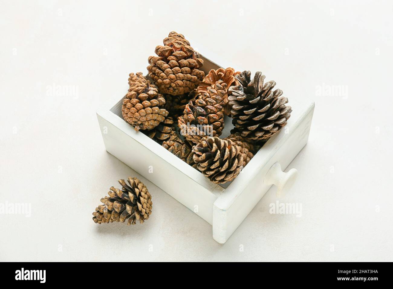 Box with pine cones on white background Stock Photo - Alamy