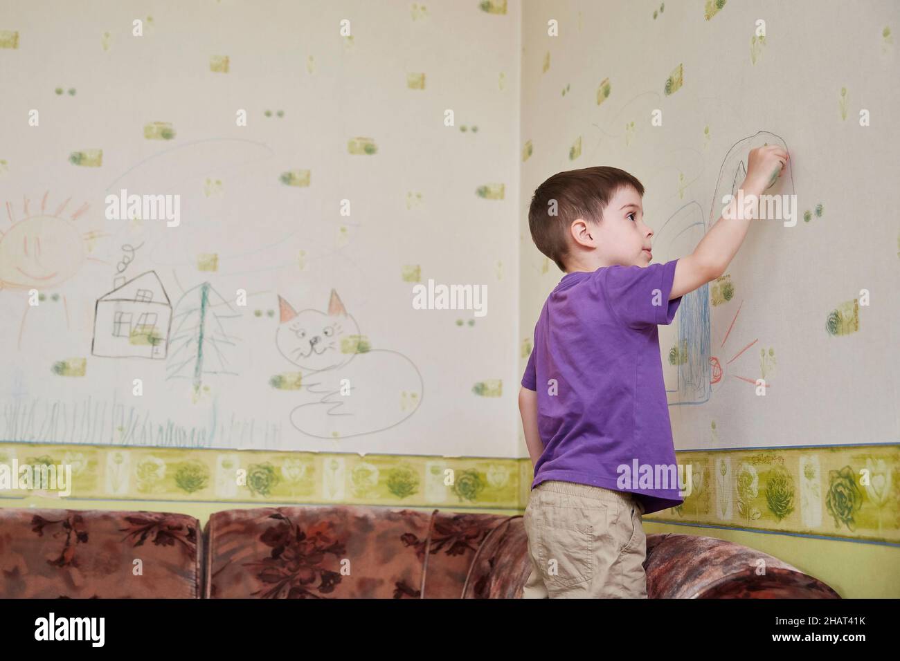 preschooler draws on the wallpaper in a room during lockdown and ...