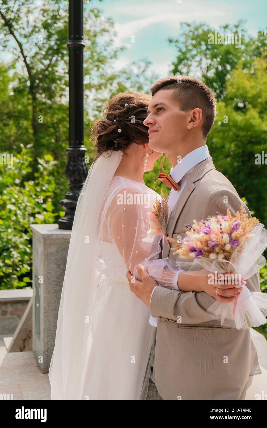 Faces happy newlyweds in the pofil. The bride and groom gently look at ...