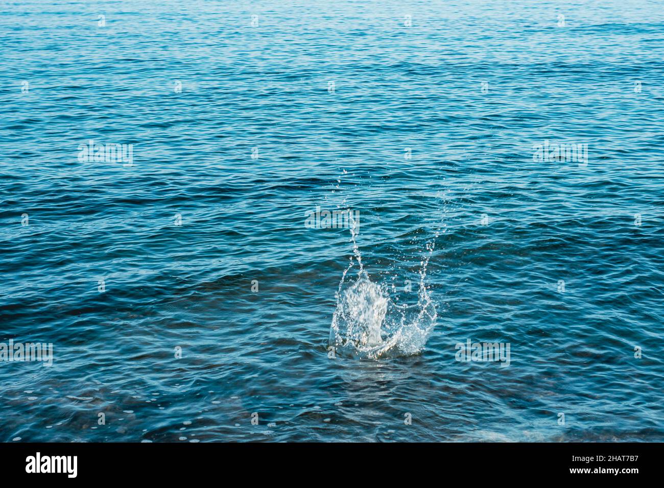 water splashed by stones thrown on the blue stagnant sea surface. Space ...
