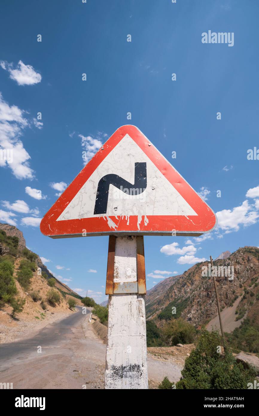 The standard triangle red and white road sign for a curvy section of a ...