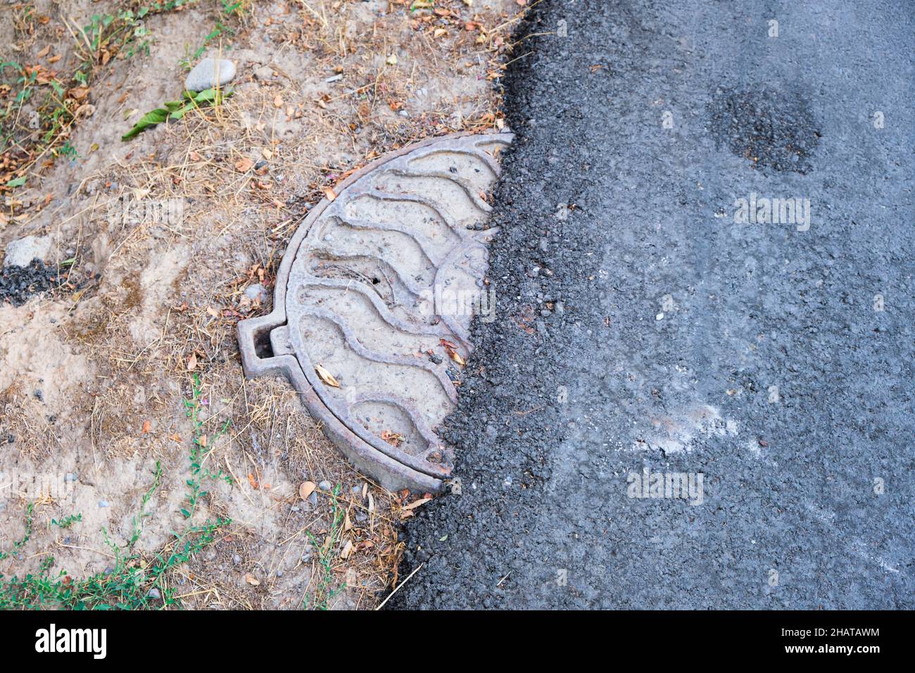 A manhole cover mistakenly paved over with asphalt. Oops! In Tashkent ...