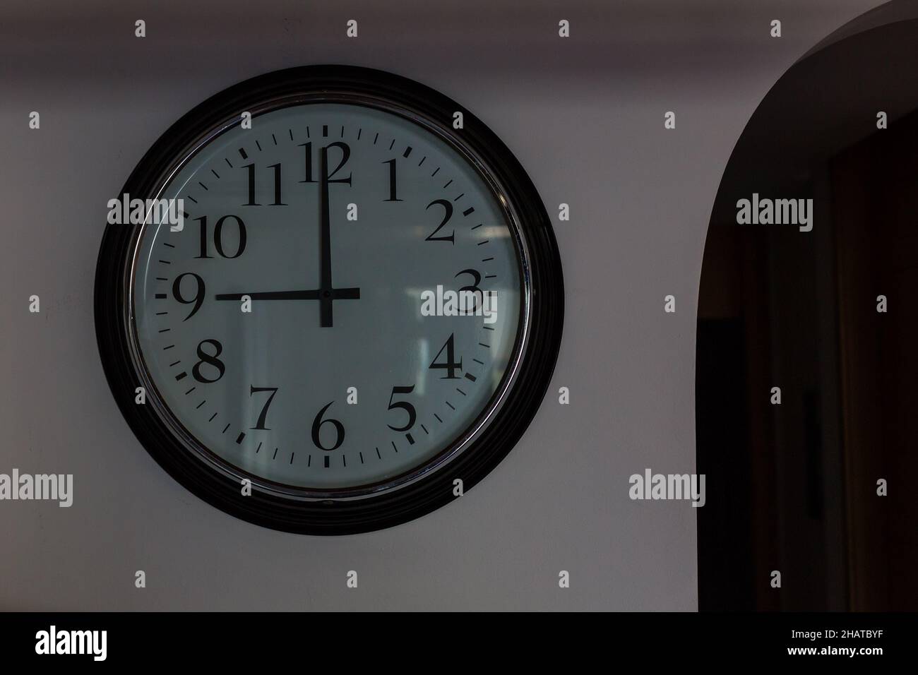 Big clock hanging on grey wall Stock Photo - Alamy