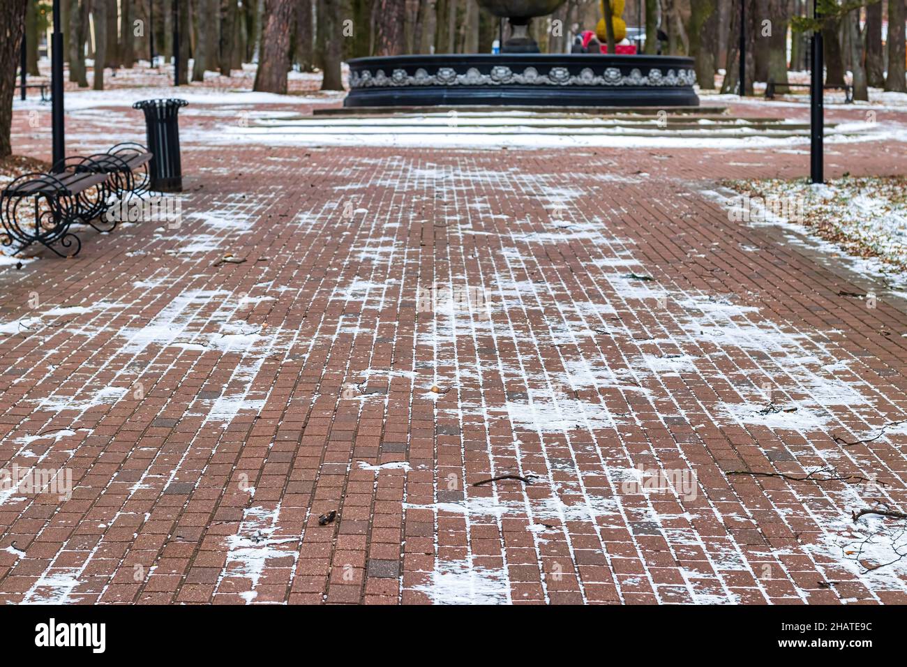 Paving paths in the park, covered with the first snow in winter. Winter ...