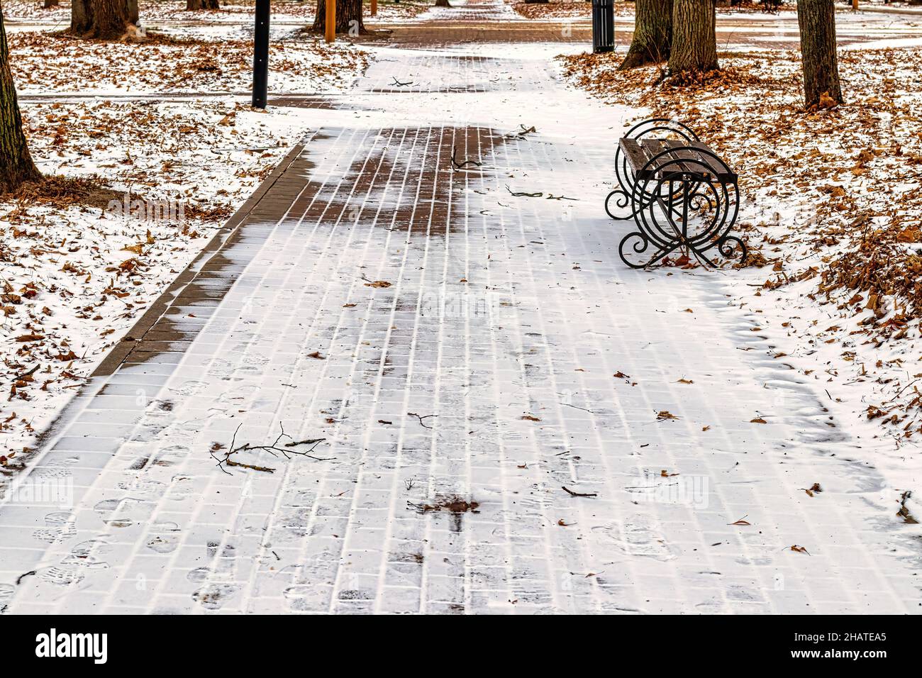 Paving paths in the park, covered with the first snow in winter. Winter ...