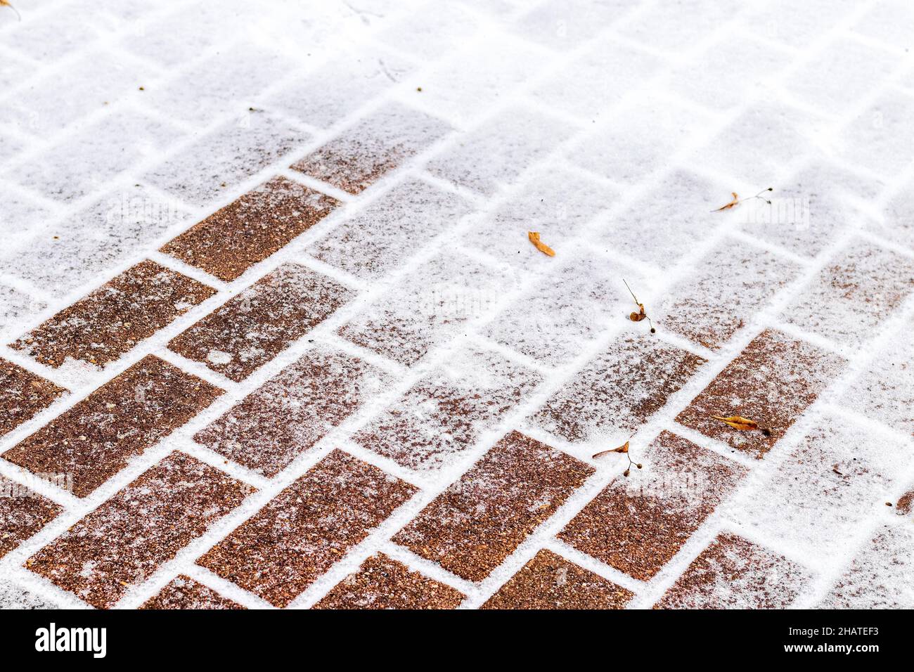 The texture of the cobblestone path covered with the first snow in ...