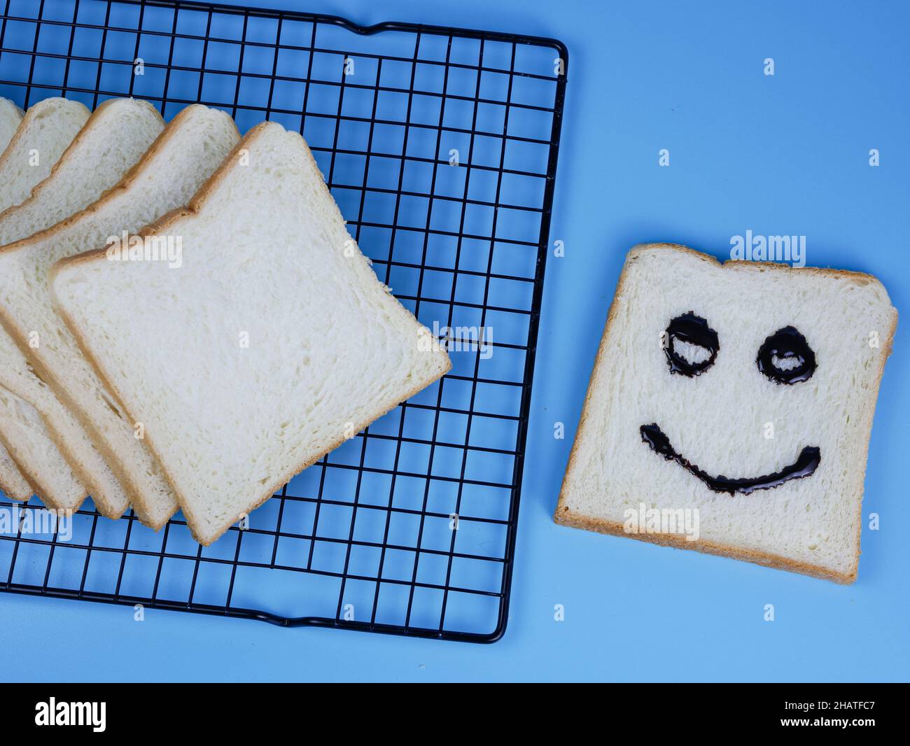 white bread with smiley emoticon on blue pastel background Stock Photo ...