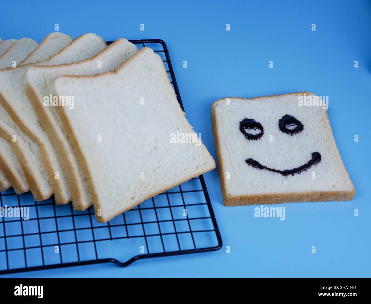 white bread with smiley emoticon on blue pastel background Stock Photo ...