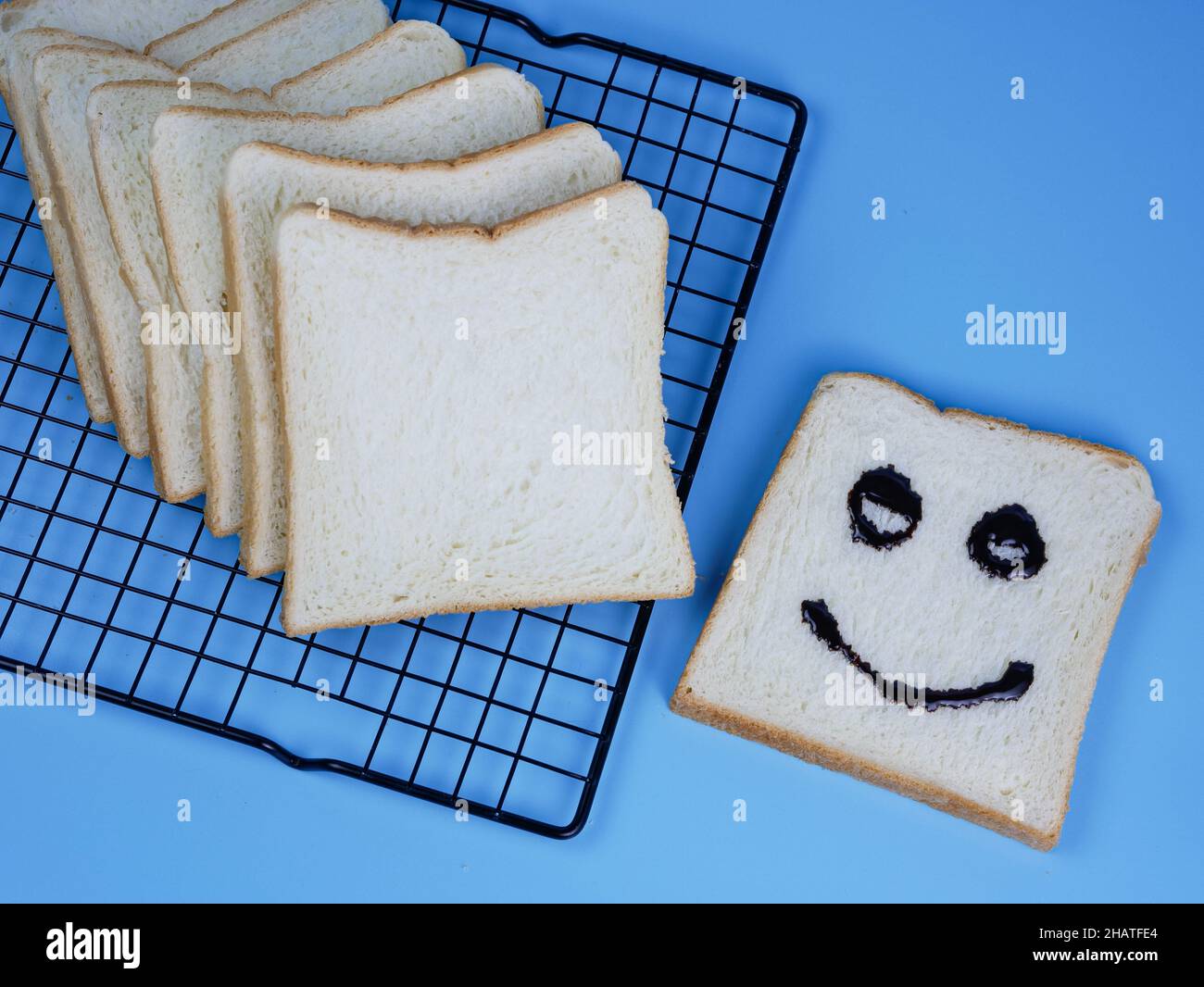 white bread with smiley emoticon on blue pastel background Stock Photo ...